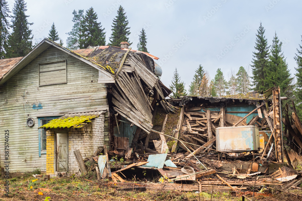 Ruined house on background of forest. Ruins of a wooden house. One ...