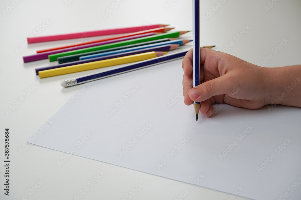 Kid hands with pencil writing in a white empty paper, child drawing ...