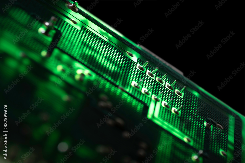 Illuminated green electronic circuit board with many electrical ...