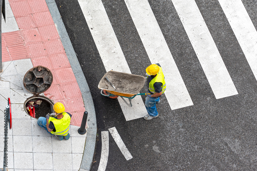trabajadores de la construcción reparando la calle y usando cemento ...