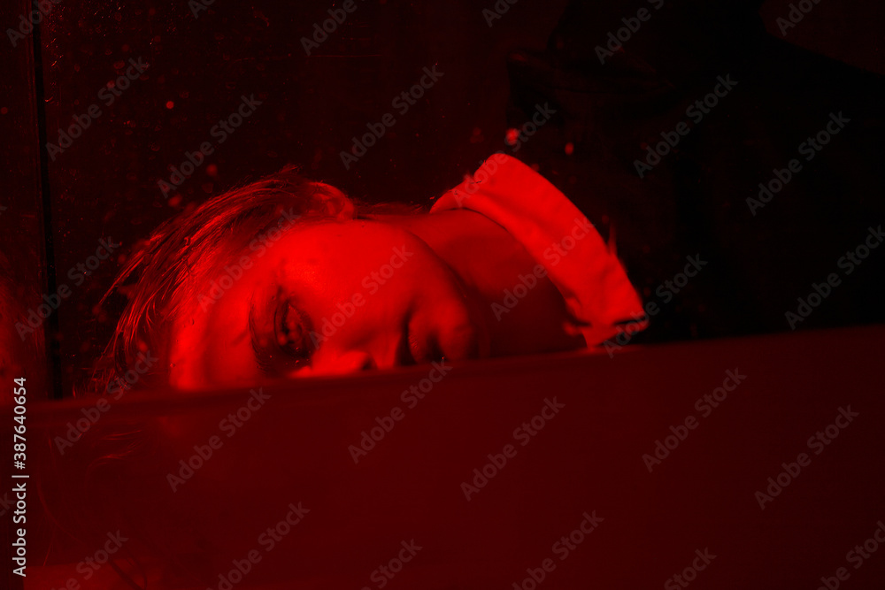 Horrible portrait of a young girl in a horror room with a red light ...