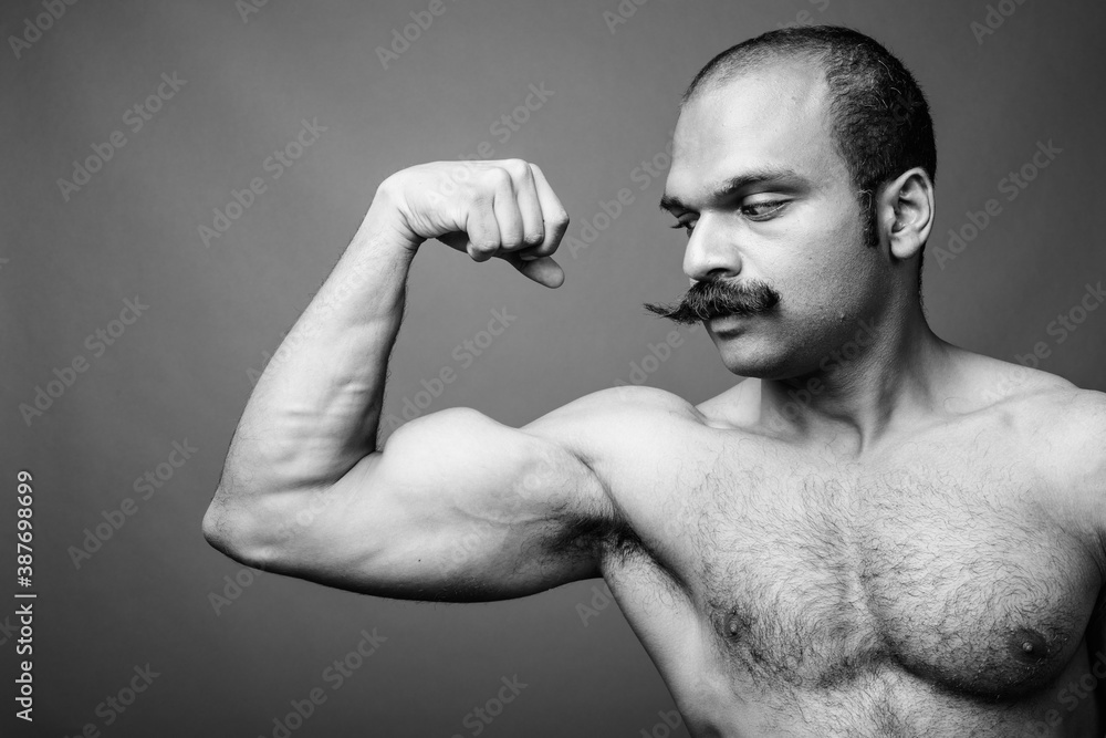Muscular Indian man with mustache shirtless against gray background ...