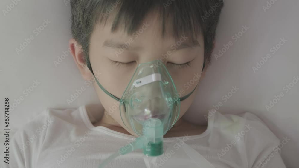 4k Top view close up at Young asian boy with oxygen mask sleep on a bed ...