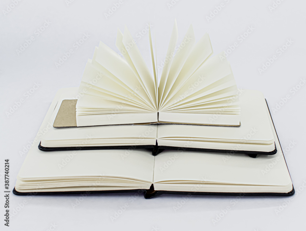 Three unfold notebooks lie on top of each other. Pyramid of books ...