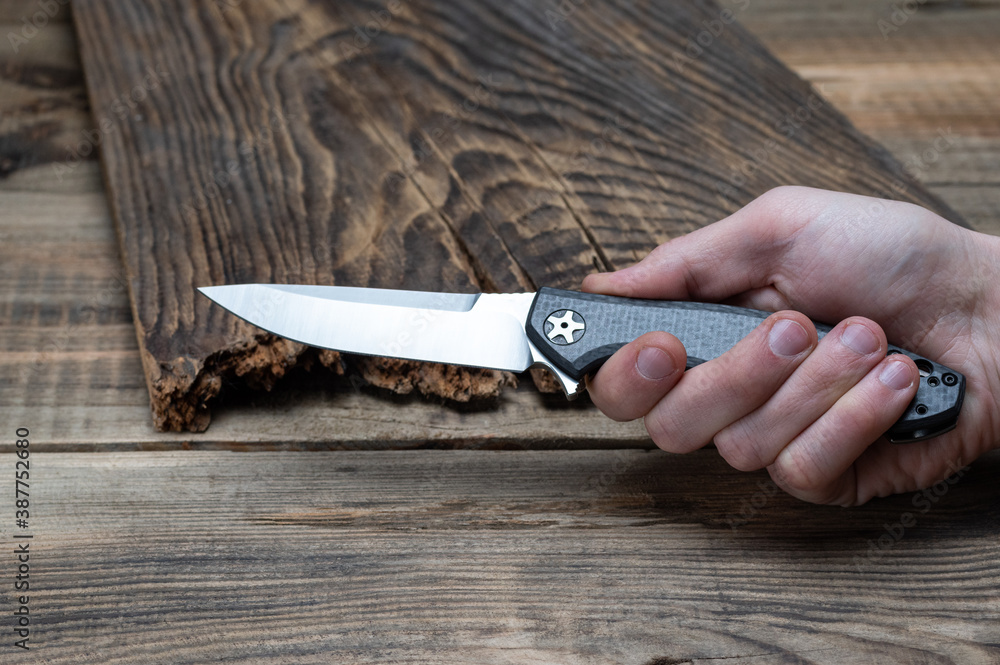 Knife with a white blade in hand. View of the knife in the hand from ...