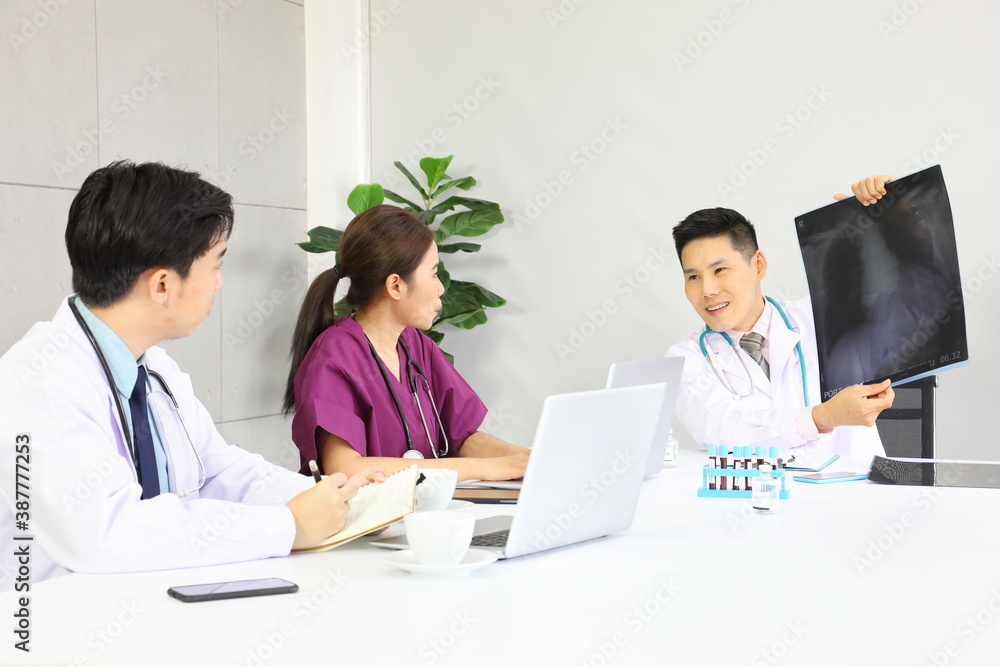 Team of doctors brainstorming and exchange idea by looking at x-ray ...
