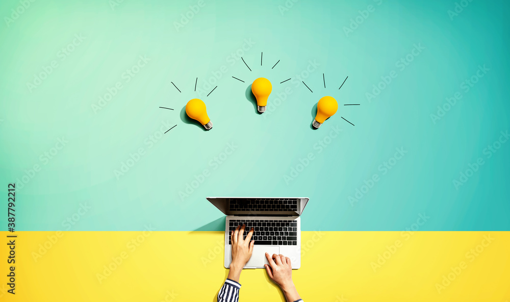 Person using a laptop computer with three light bulbs from above Stock ...