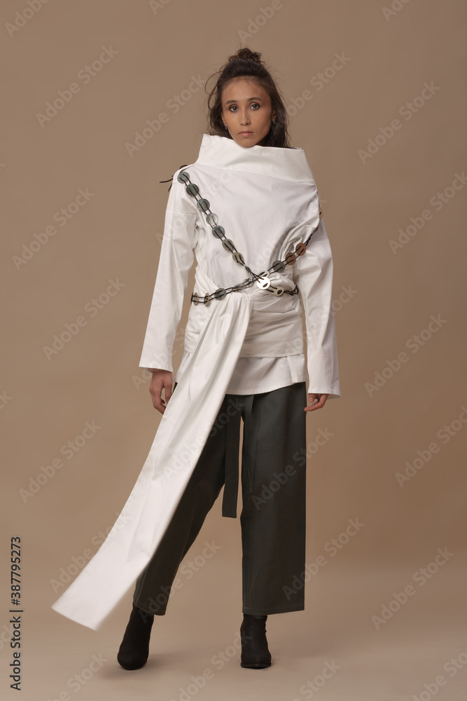 Mongol model posing full height in a white cotton blouse and khaki ...