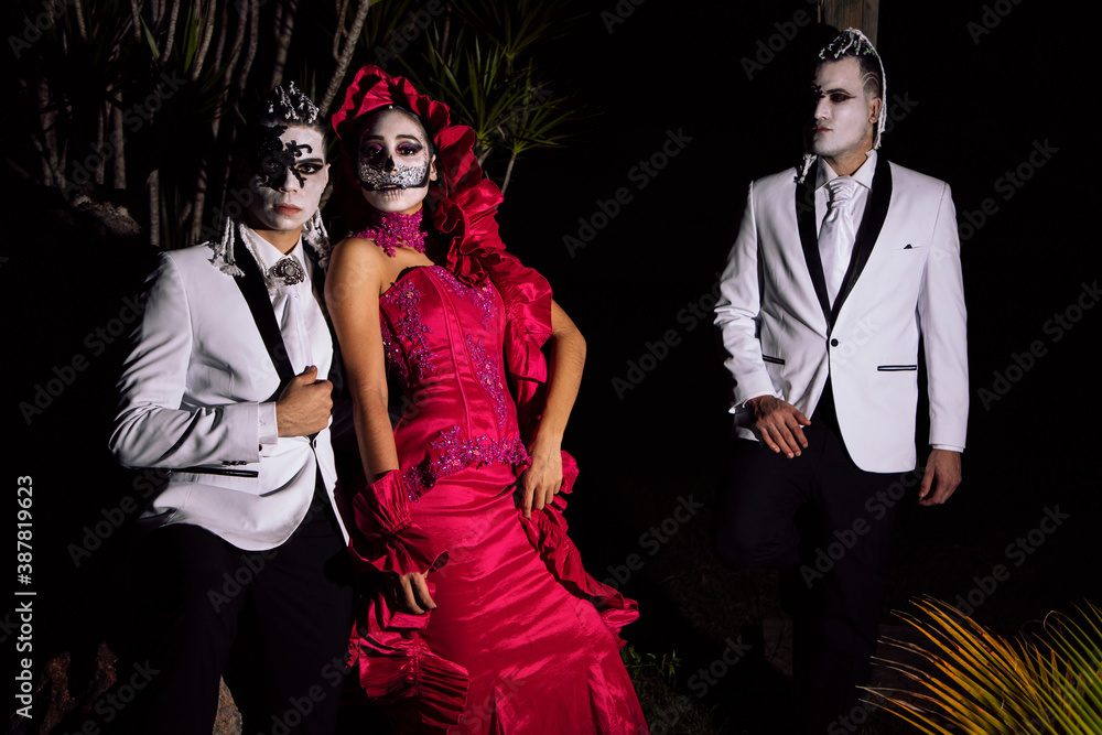 A catrina and two catrin wearing elegant clothes in a dark forest at ...