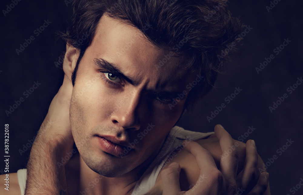 Sexy serious look professional male model posing on dark shadow ...