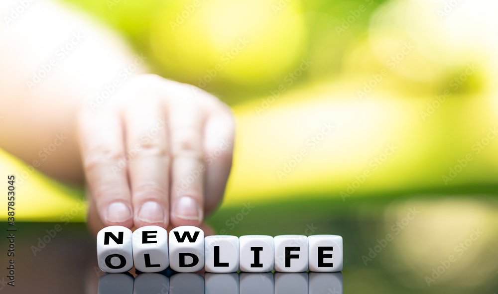Hand turns a dice and changes the expression "old life" to "new life ...