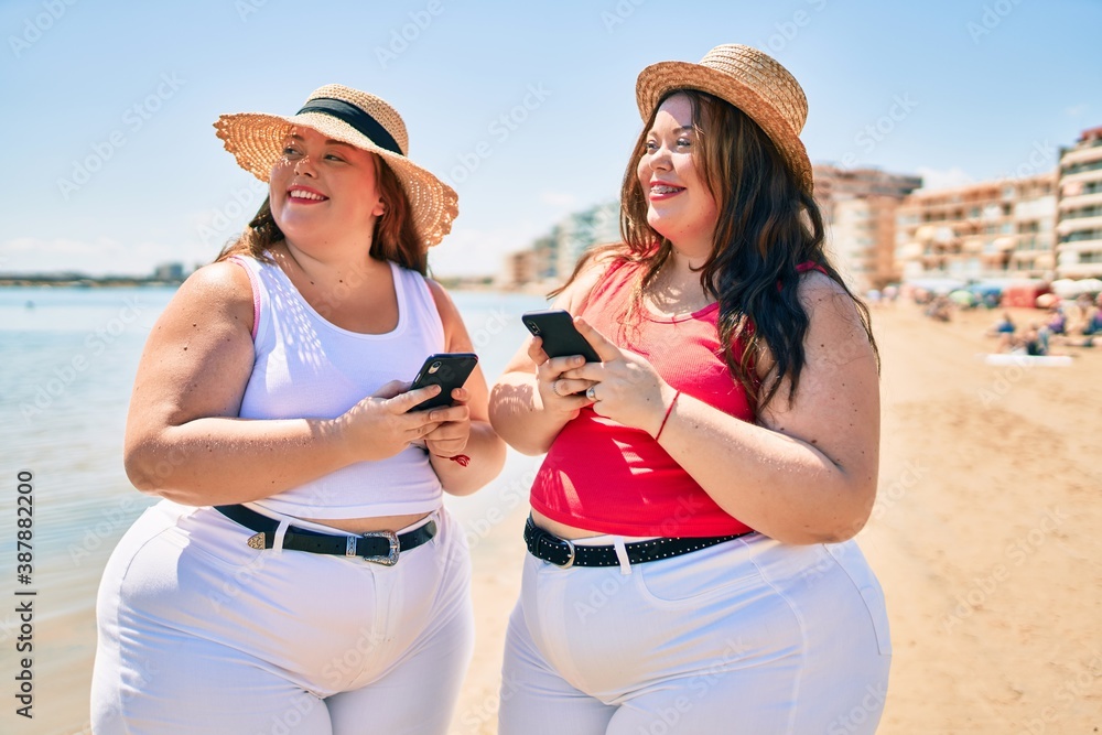 Two plus size overweight sisters twins women happy at the beach on ...