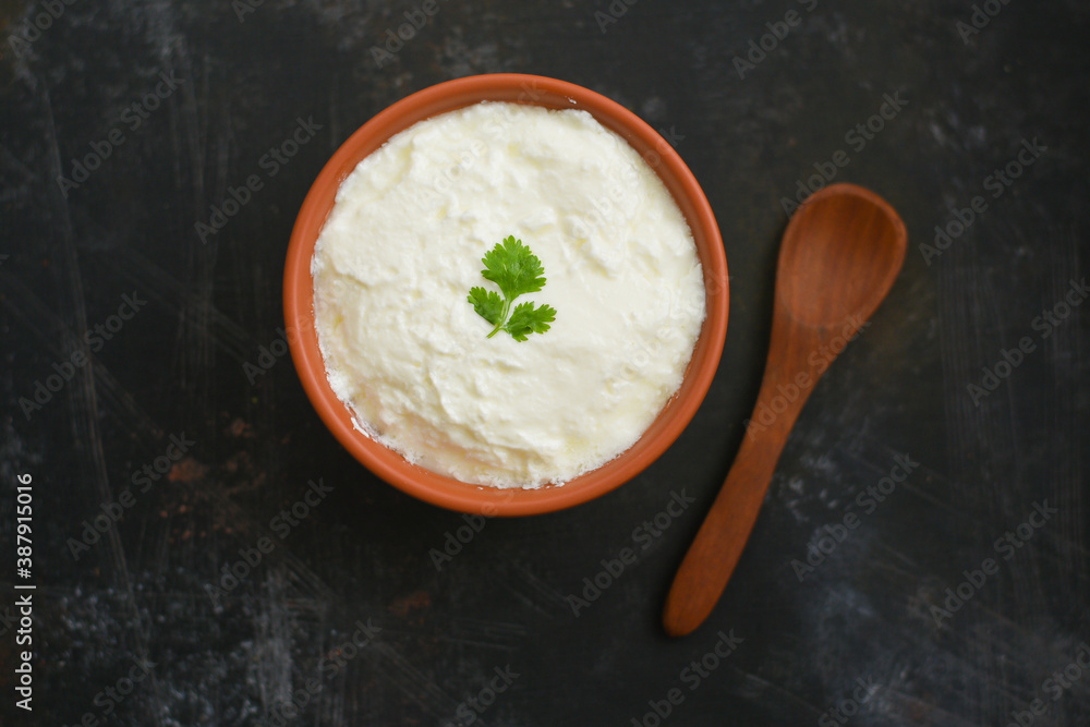 Bowl of homemade sour cream curd yogurt Dahi fresh herbs curry leaf ...