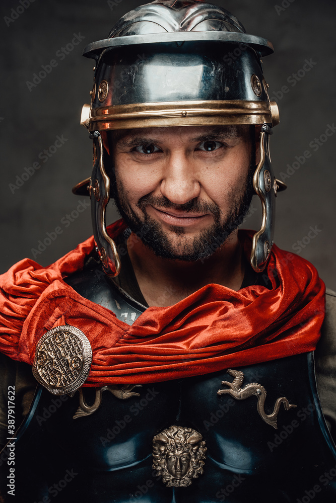 Smiley mature roman soldier in black armour with helmet and red mantle ...