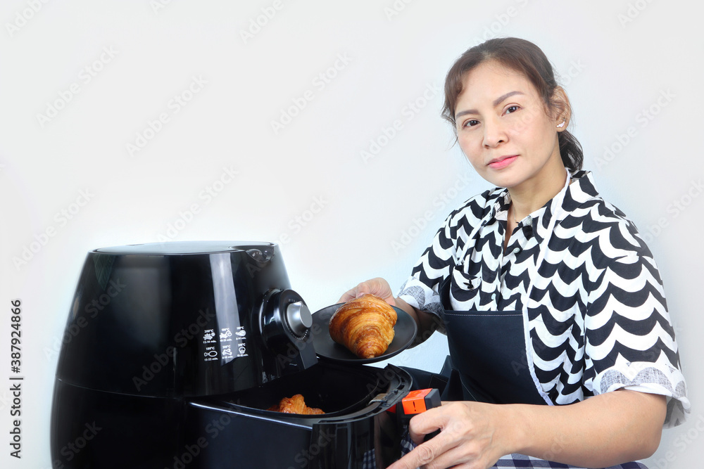 an asian lady woman model is cooking the croissant for the breakfast by ...