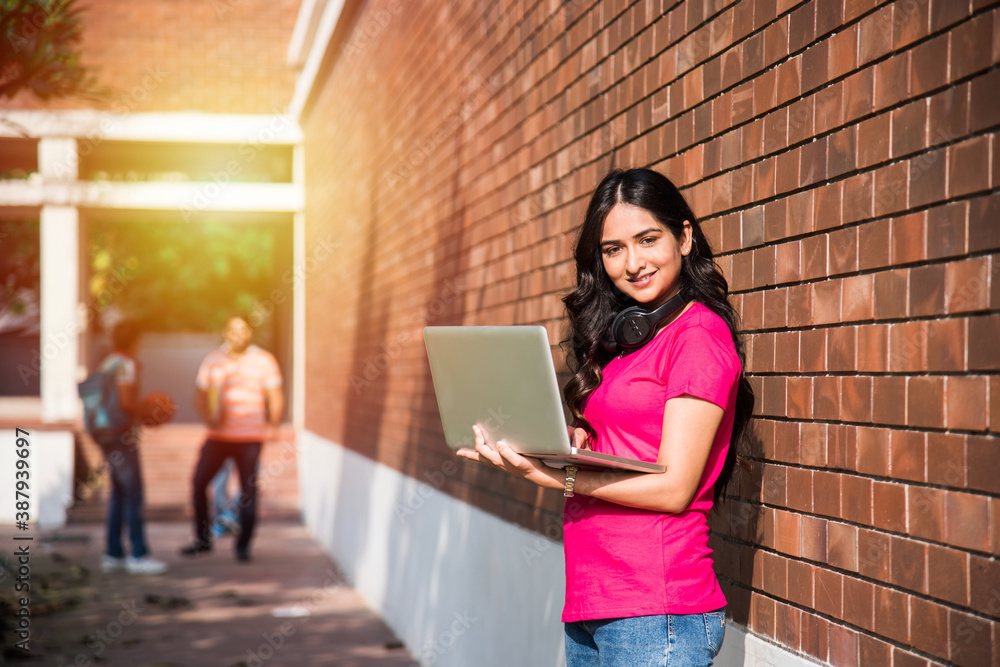 One Indian college student with laptop or book in focus with friends in ...