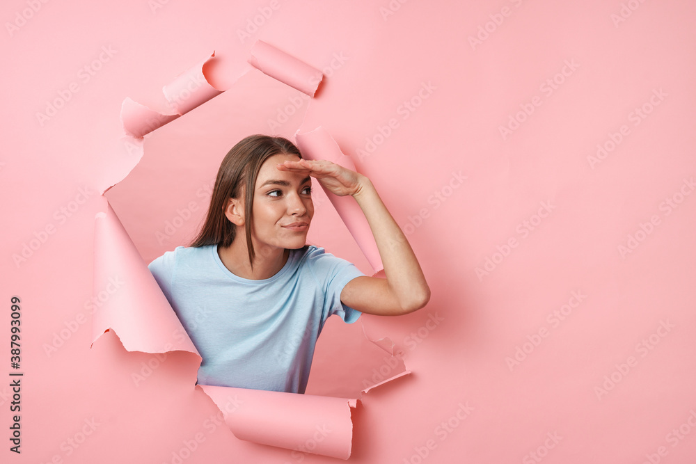 Lovely young girl peeking out of the paper hole Stock Photo | Adobe Stock