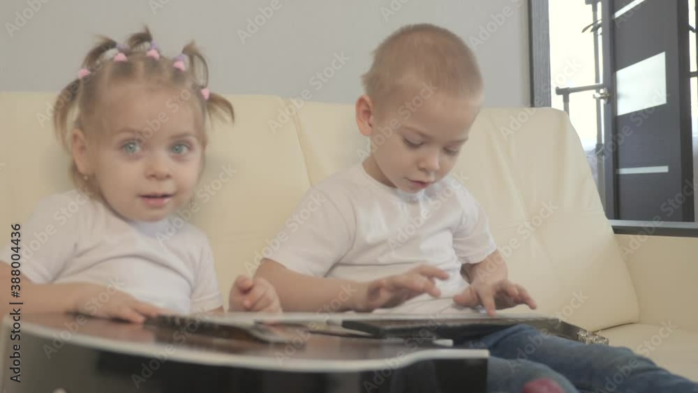 children messing around playing acoustic guitar. teamwork concept happy ...