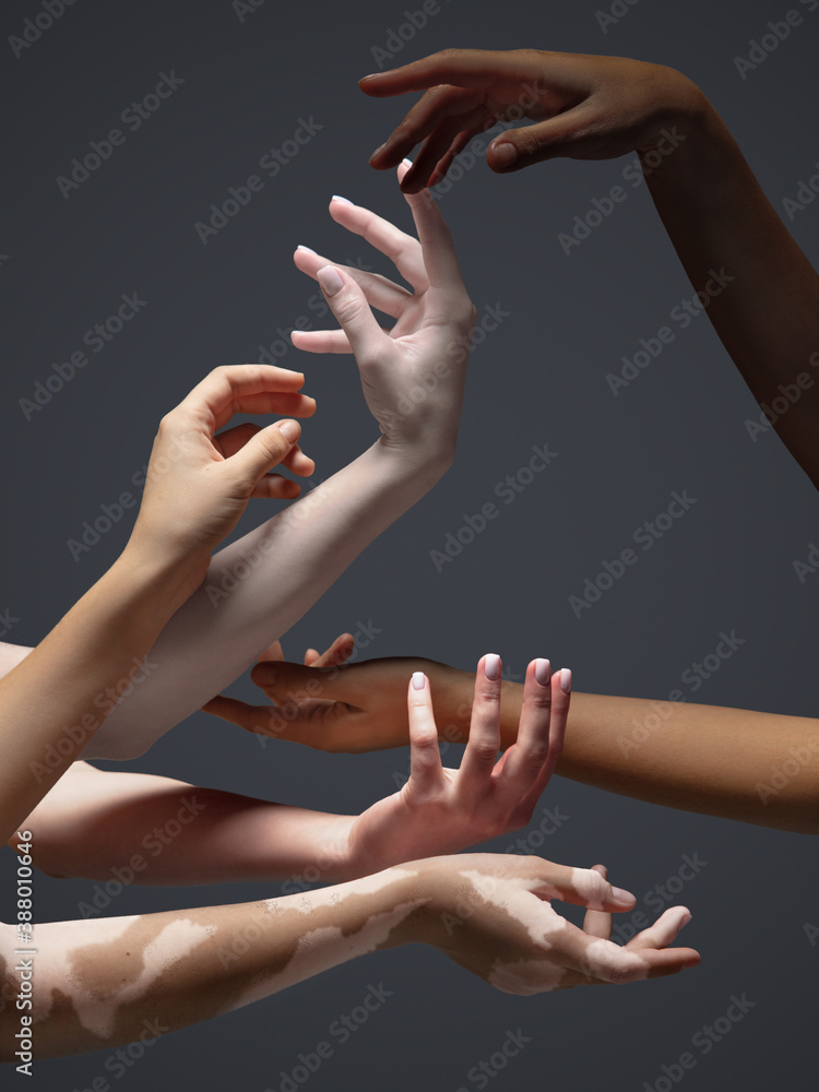 Common goal. Hands of different people in touch isolated on grey studio ...