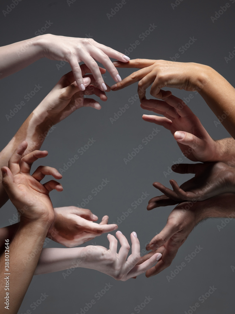 Saving kindness. Hands of different people in touch isolated on grey ...