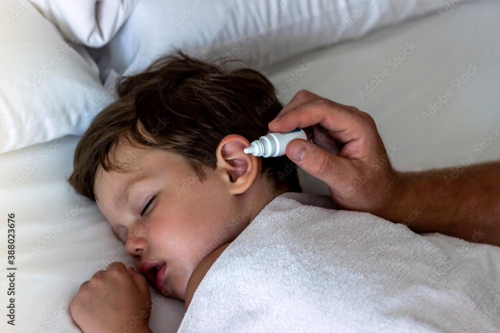 Father dribble medication into boy ear.Photo of a dad dripping ear ...