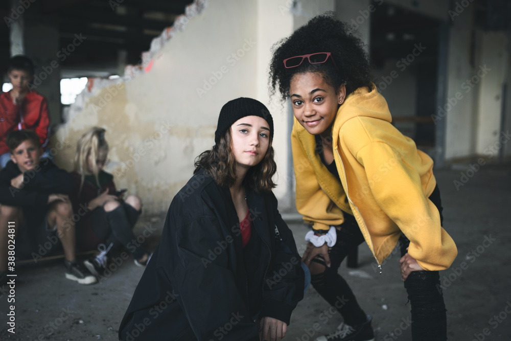 Group of teenagers girl gang standing indoors in abandoned building ...