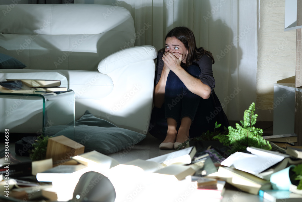 Scared woman hiding from intruder during home robbery Stock Photo ...