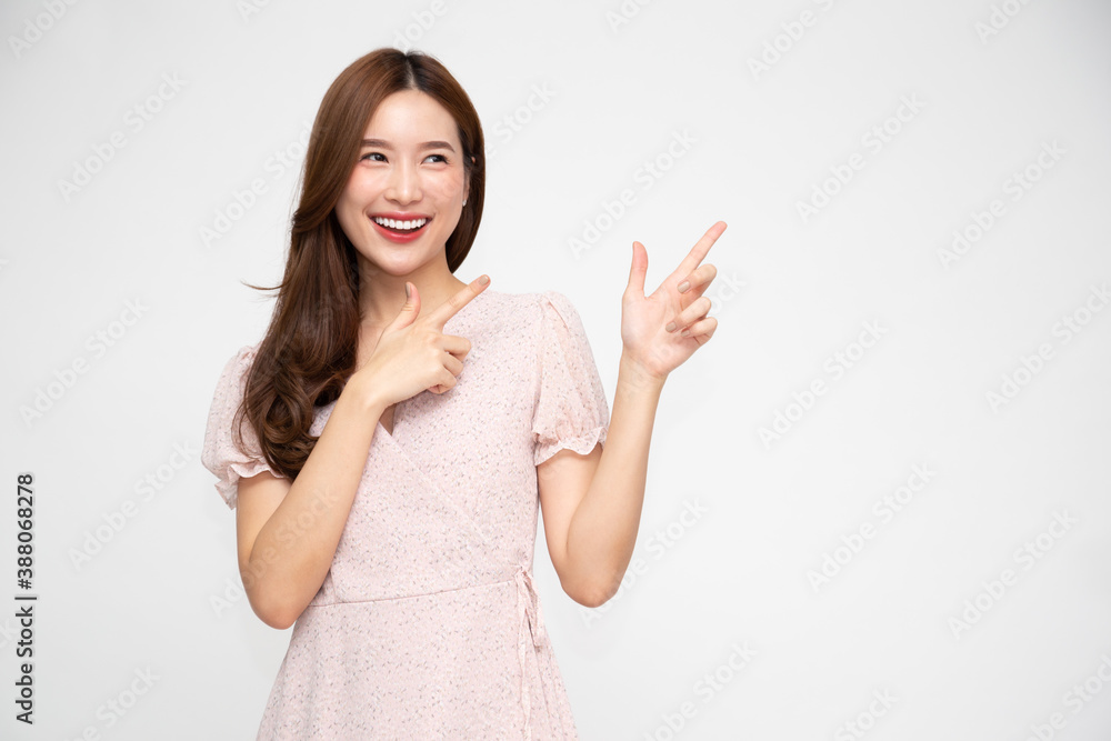 Young elegant beautiful Asian woman smiling and pointing to empty copy ...