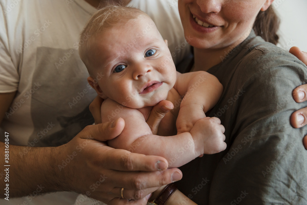 Baby in the arms of parents Stock Photo | Adobe Stock