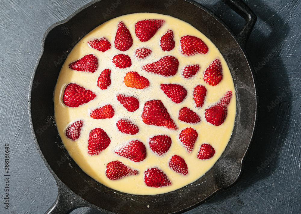 Pre-cooked Strawberry clafoutis in cast iron pan Stock Photo | Adobe Stock