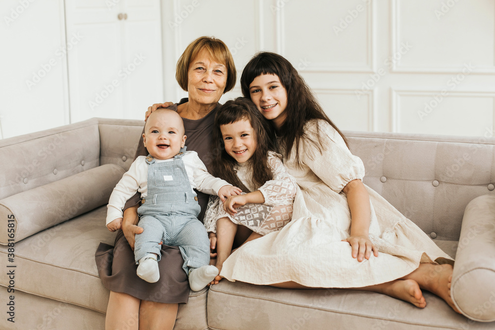Portrait of a beautiful grandmother and her three grandchildren. Woman ...