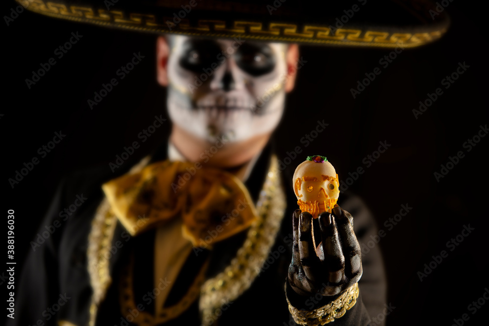Mexican charro holding a candy skull in his hands on day of the dead ...