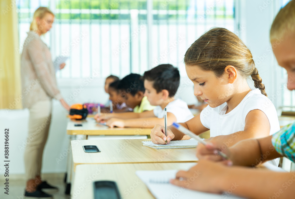 Side view of group of primary school students and positive girl at a ...