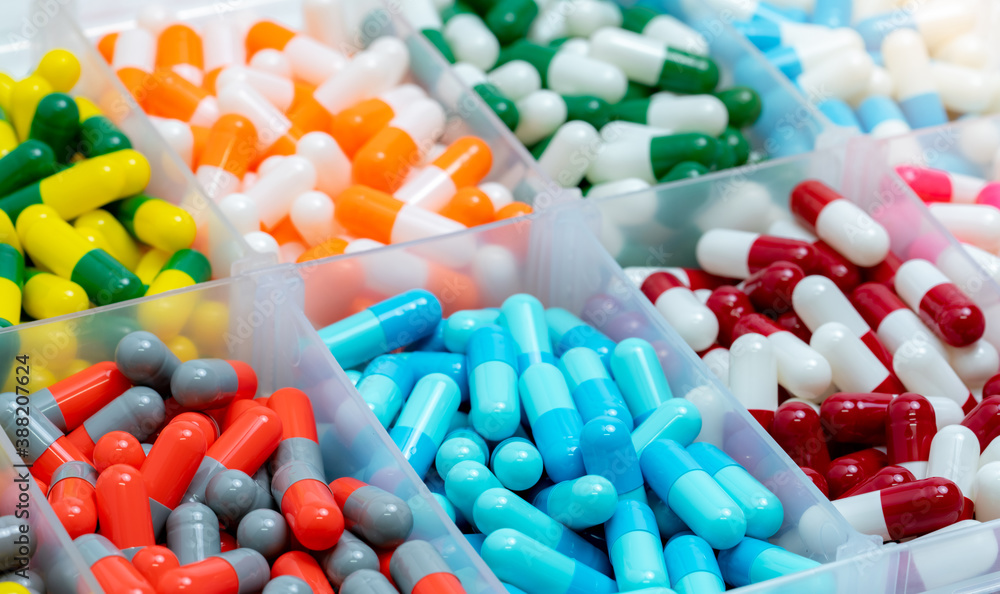 Colorful capsules pill in plastic box. Pharmaceutical industry ...