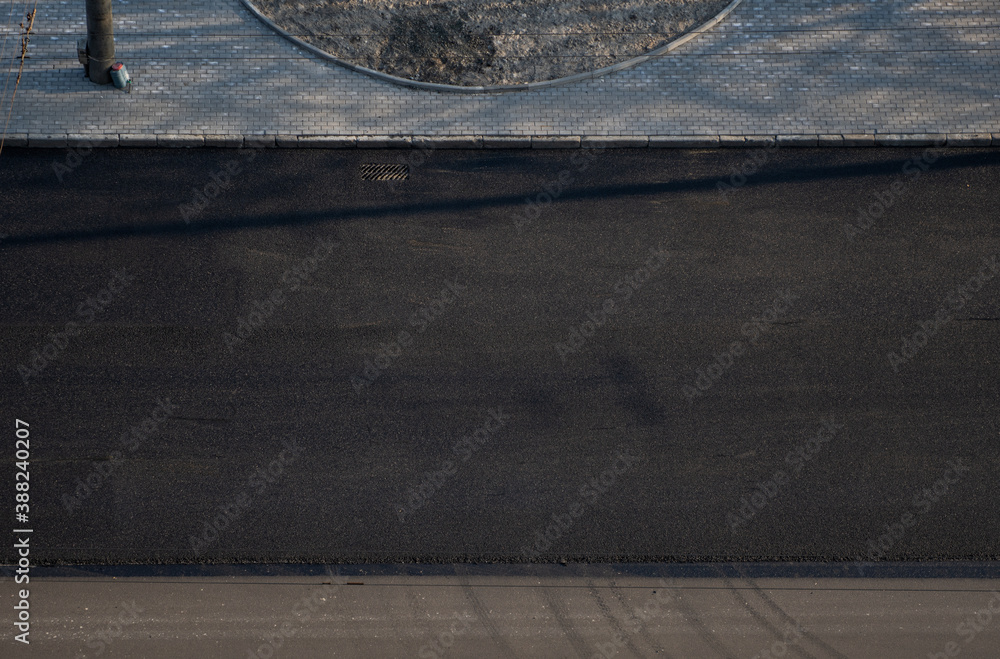 Freshly laid black bitumen asphalt with a high edge to the gravel ...