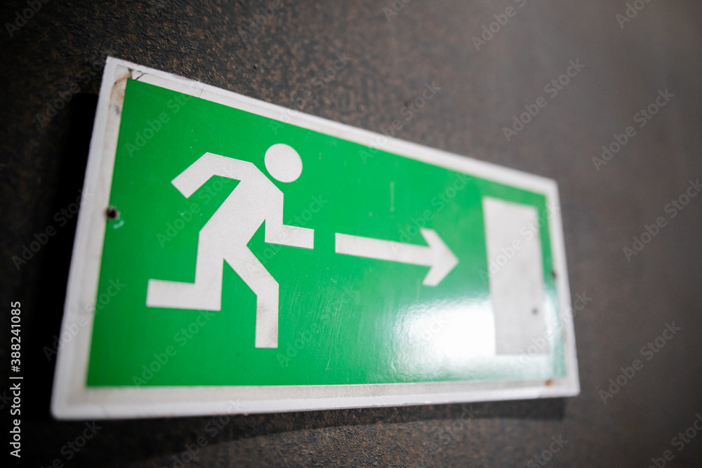 Emergency exit sign, escape sign on the wall. Safety sign in office ...