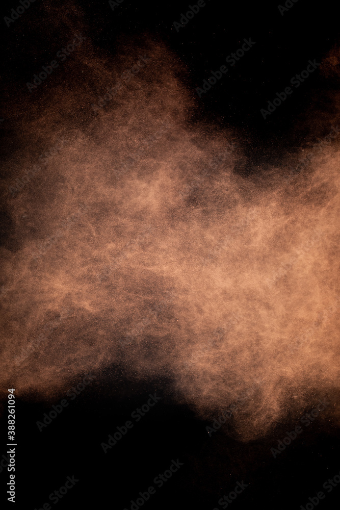 Flying cocoa powder on isolated black background, brown chocolate dust ...