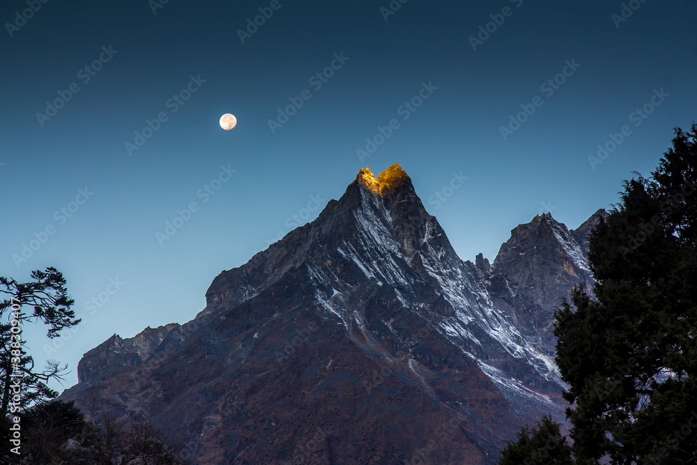 Early morning: sun lights high peak of Kongde Ri mountain of the ...