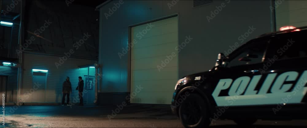 Video Stock WIDE Police officer exiting a car and approaching two multi ...