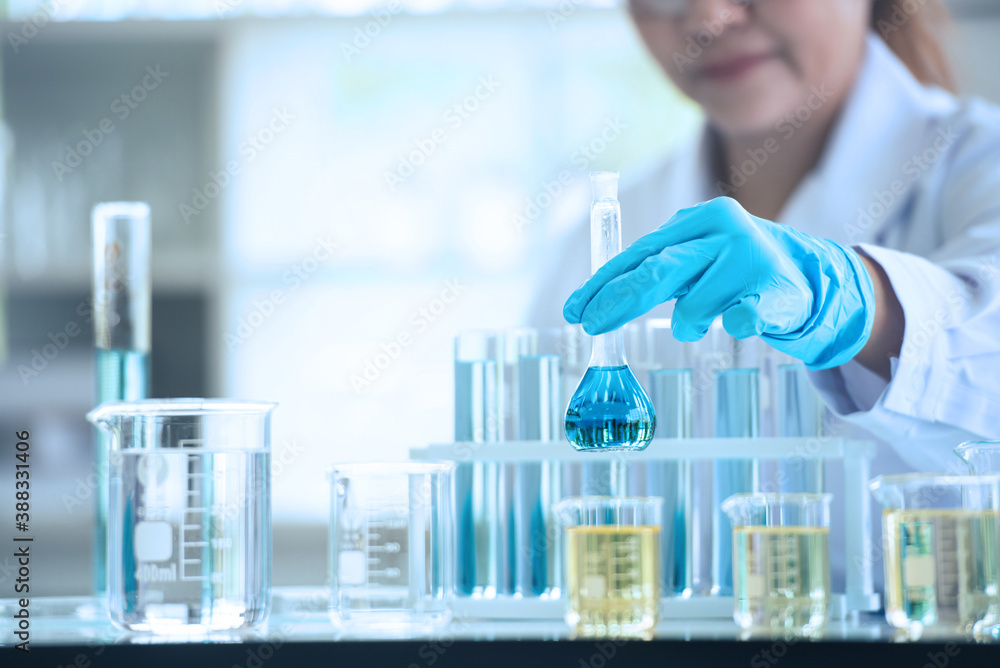 Scientist woman working with liquids in glassware. Asian scientist ...