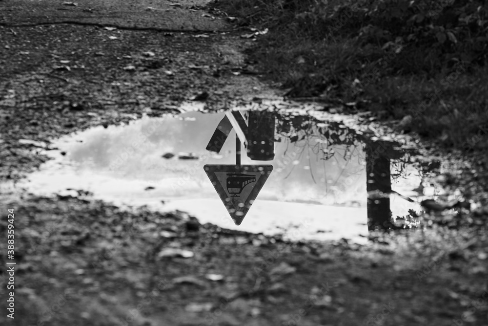 Traffic sign for ungated level crossing reflects in rain puddle Stock ...