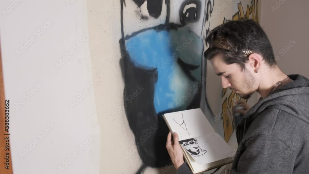 Young artist launching a graffiti message to raise awareness about ...