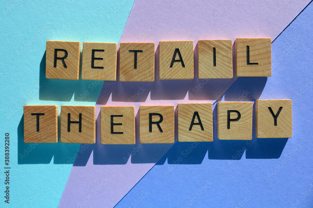 Retail therapy, words in wood alphabet letters isolated on coloured ...