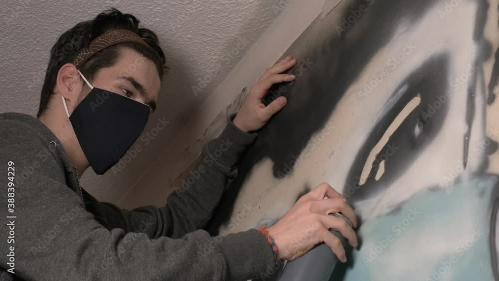 Young artist launching a graffiti message to raise awareness about ...