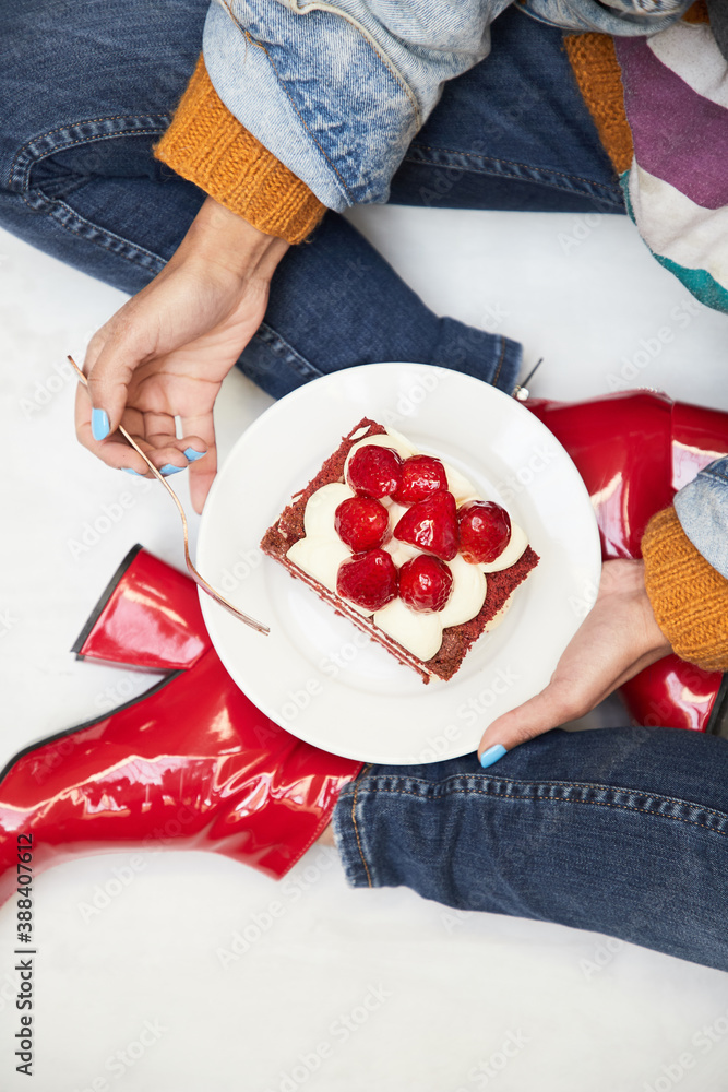 Modelo femenina en botas rojas y denim sosteniendo torta red velvet ...