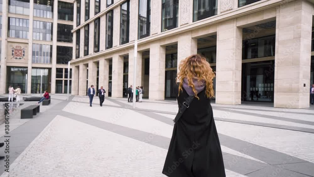Woman takes photos with professional camera of business building ...