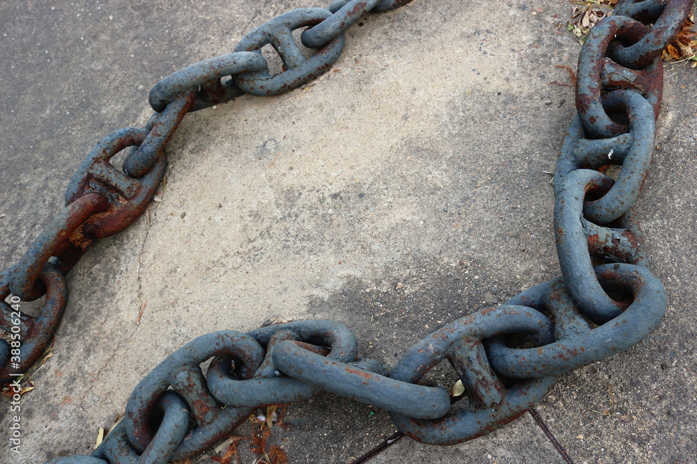 ancient heavy anchor chain with thick links, on a ground with sand ...