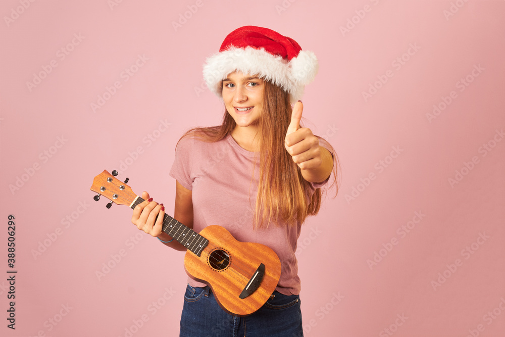 young performer woman playing ukulele and wearing Santa Claus with ...