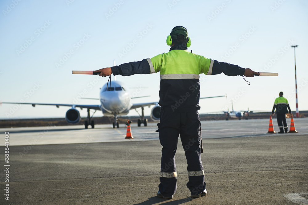 The runway traffic controller uses gestures and sticks to help the ...