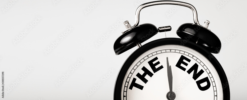 The end wording inside alarm clock with white background and copy space ...